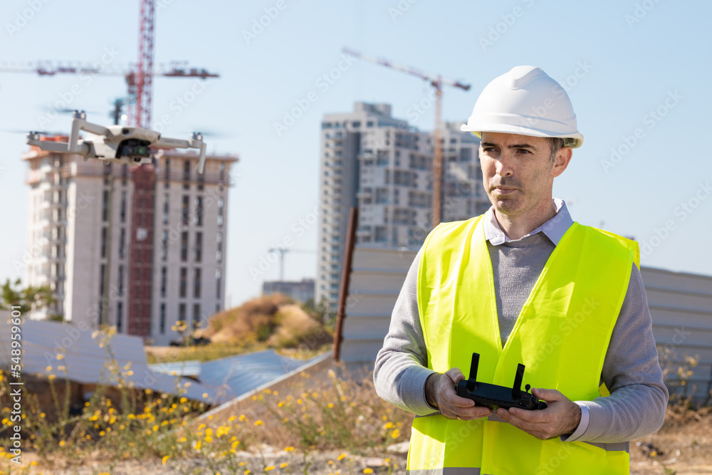 Man launches a quadcopter. An engineer flies a drone next to a ...