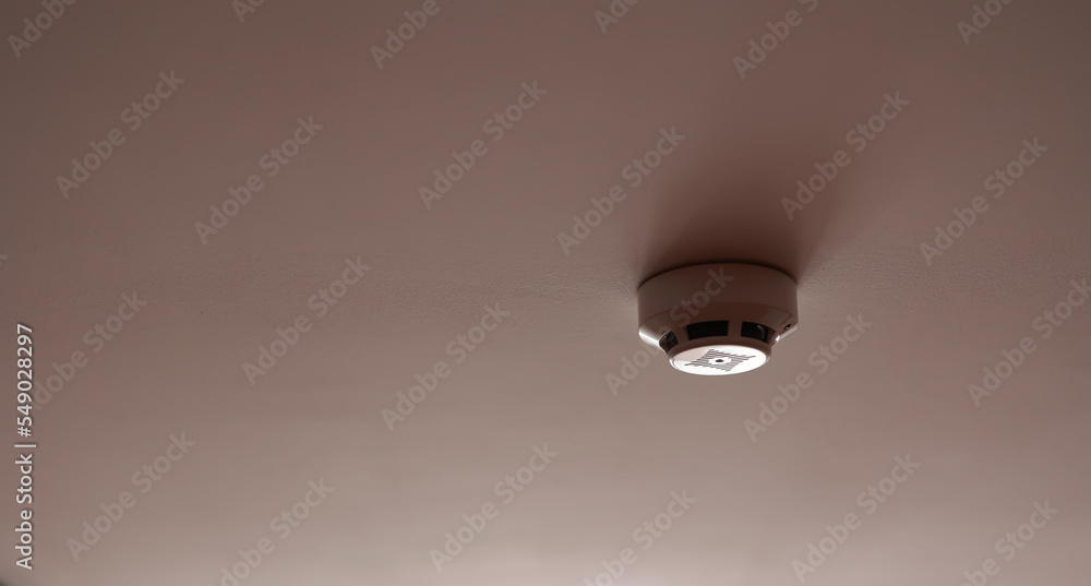 Fire system indoors. White smoke detector issue a signal to a fire ...