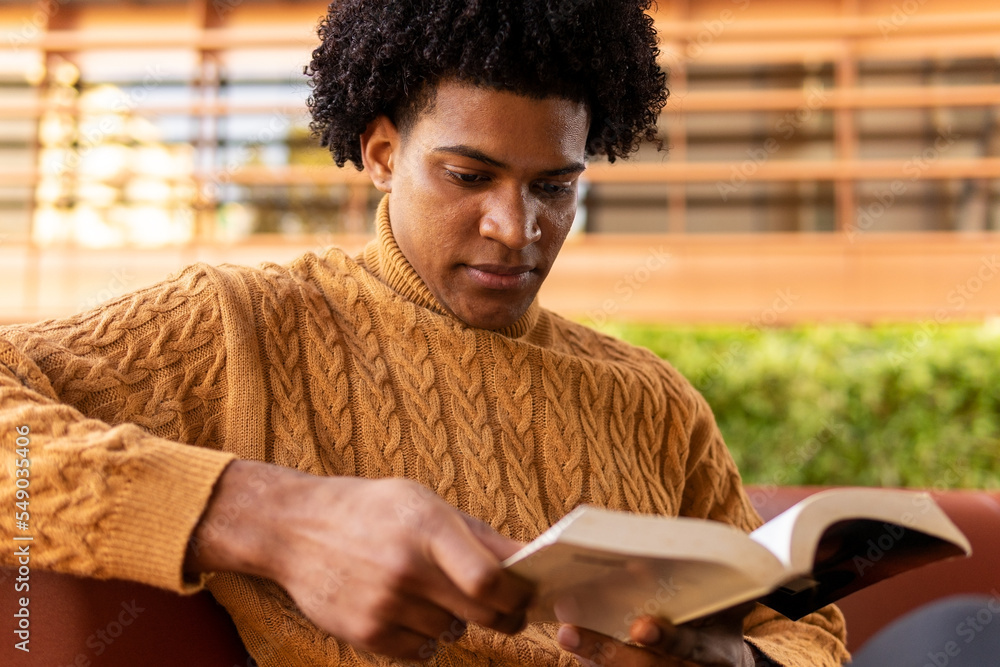 Clever black man reading story in book Stock Photo | Adobe Stock