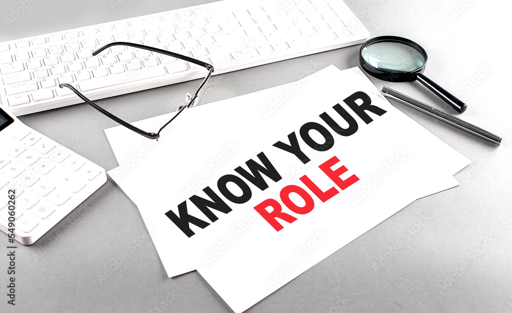 KNOW YOUR ROLE text on a paper with keyboard, calculator on grey ...