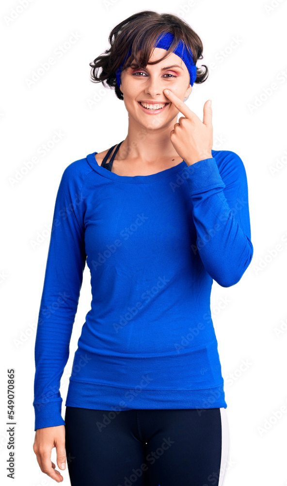 Beautiful young woman with short hair wearing training workout clothes ...