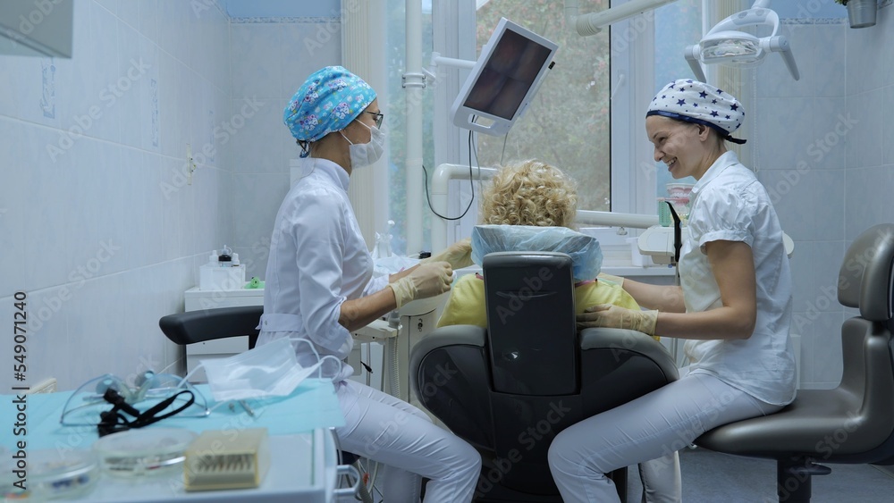 Patient receiving dental treatment in dental office, dentist and ...