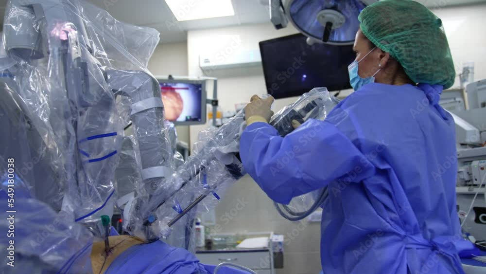 Medic turns the robotic arm input into patient’s body. Specialist ...