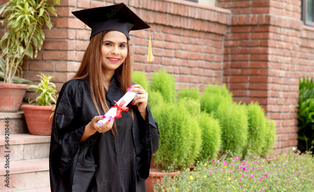 Foto de Young indian graduated girl holding his graduation degree ...