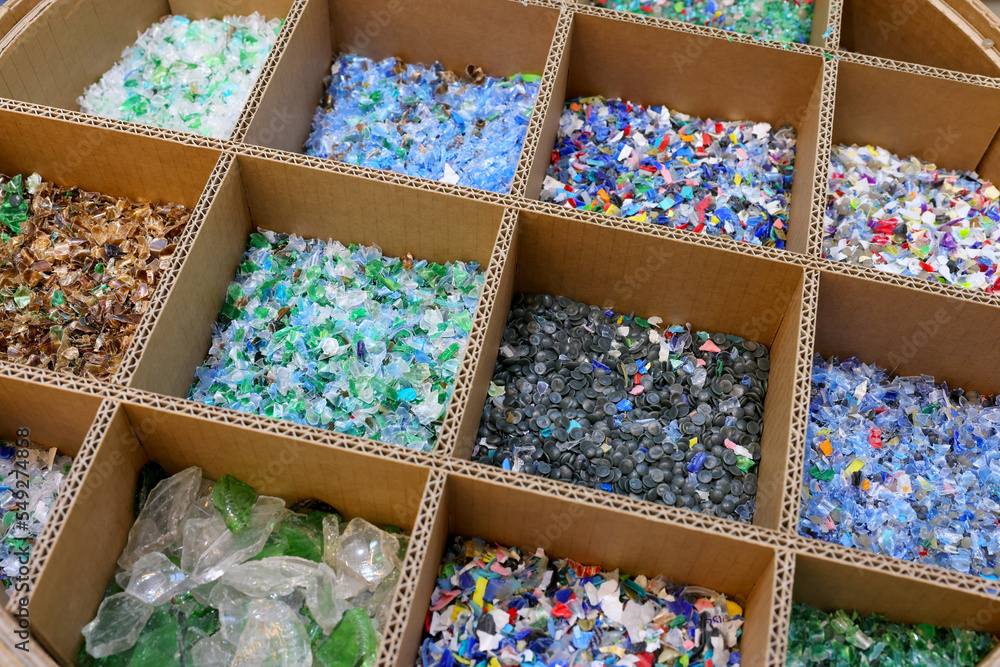 Small pieces of plastic placed in a compartmentalized cardboard box are ...