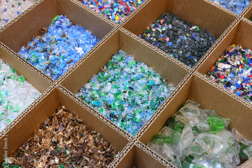 Small pieces of plastic placed in a compartmentalized cardboard box are ...