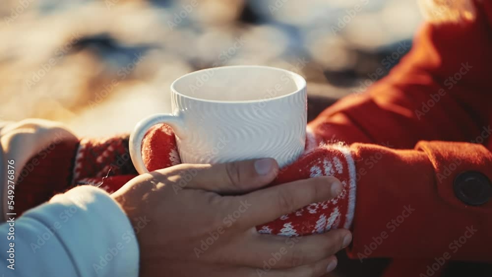Close up hands of couple holding cups with hot tea at winter christmas ...