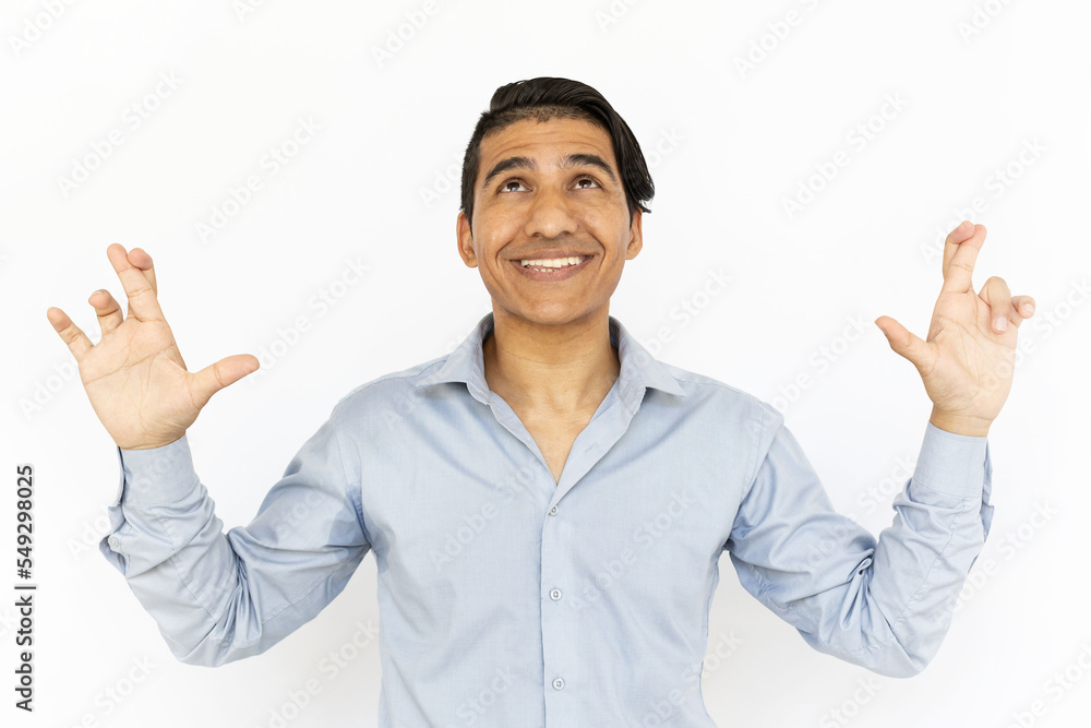Happy man with crossed fingers standing against white background ...