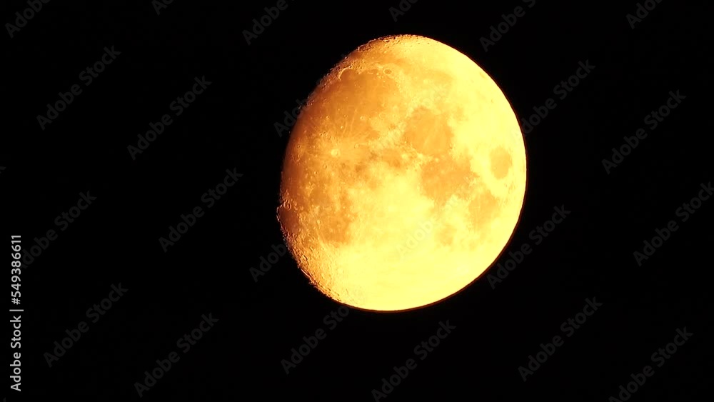 A glowing golden huge moon seen from earth through the atmosphere ...