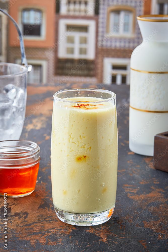 Kesar Saffron Lassi with honey served in glass isolated on table top ...