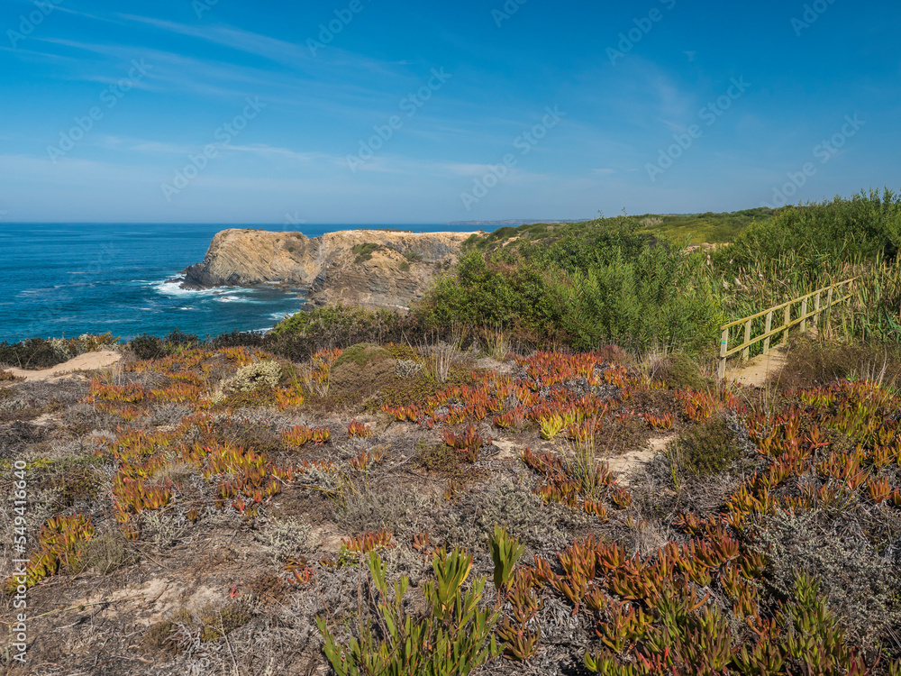View of sea shore with small wooden bridge, ocean waves, cliffs and ...