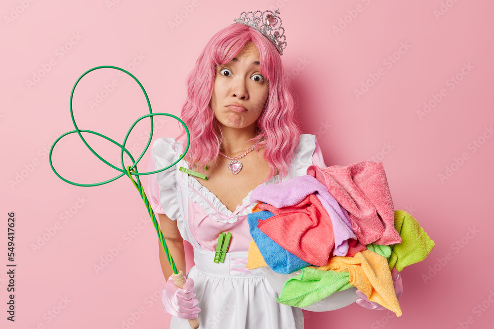 Surprised housemaid holds carpet beater and basin full of colorful ...