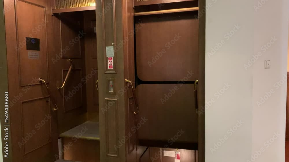 Motion of wooden vintage open, no door paternoster lift at Prague's New city hall. Tourists very ...