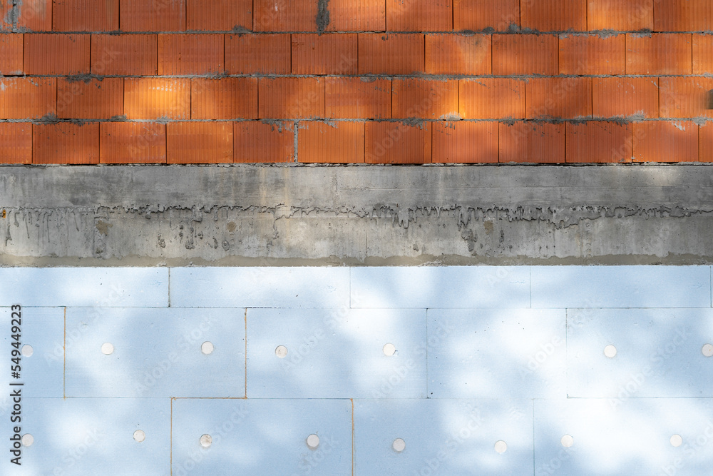 Building wall with red brick, panel blocks and styrofoam insulation ...