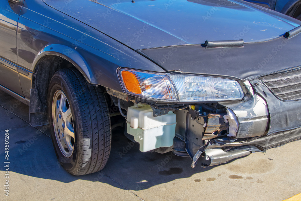 Wrecked car - silver blue sedan showing passenger front that has been ...