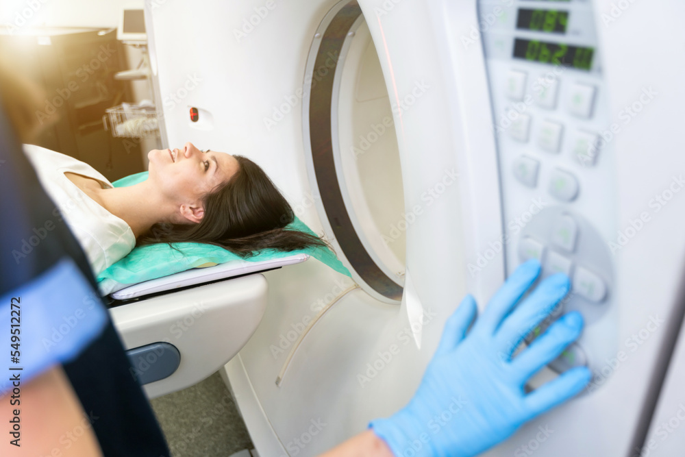 CT scan technologist overlooking patient in Computed Tomography scanner ...