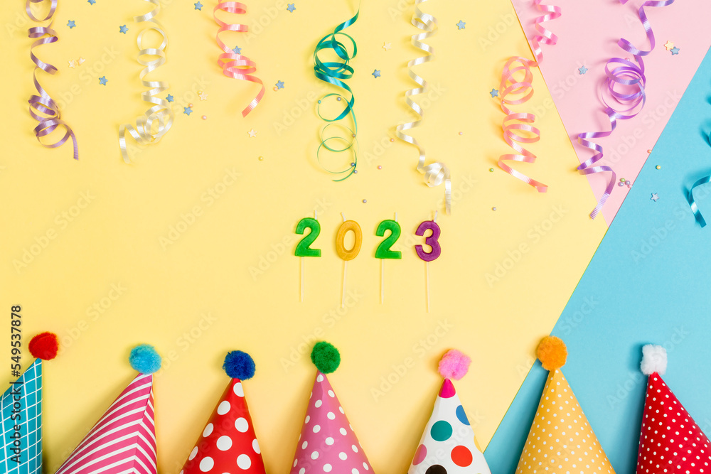 2023 party theme with with hats and streamers on a vibrant background ...
