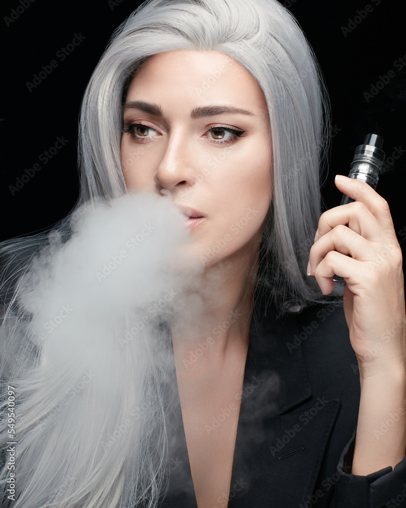 Sensual Silver Haired Woman Vaping Beautiful Woman With A Vape Blowing Smoke From Between Her