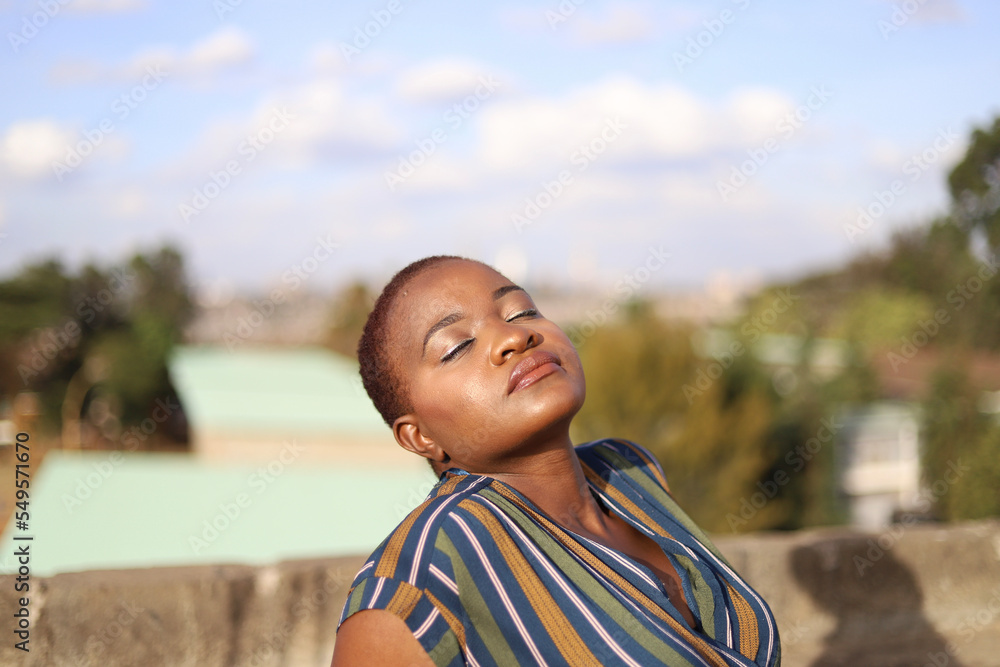 Foto de Black woman with sun on her face do Stock | Adobe Stock