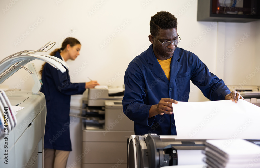 Serious middle-aged African American man in uniform loading large ...