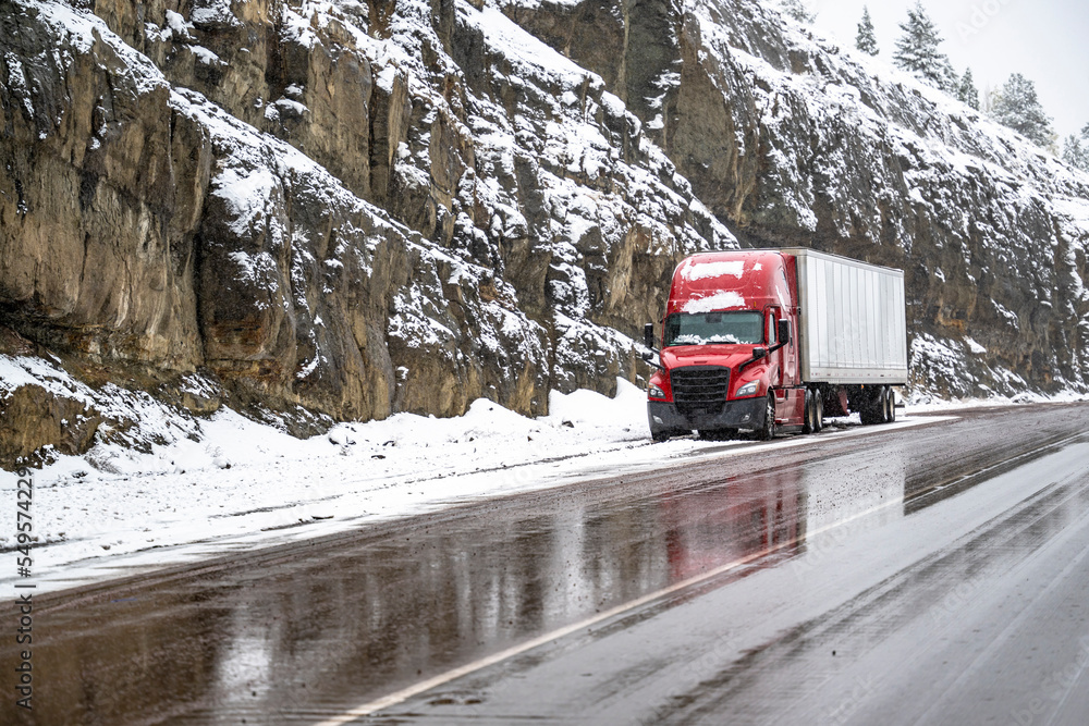 Shiny red big rig semi truck with dry van semi trailer standing out of ...