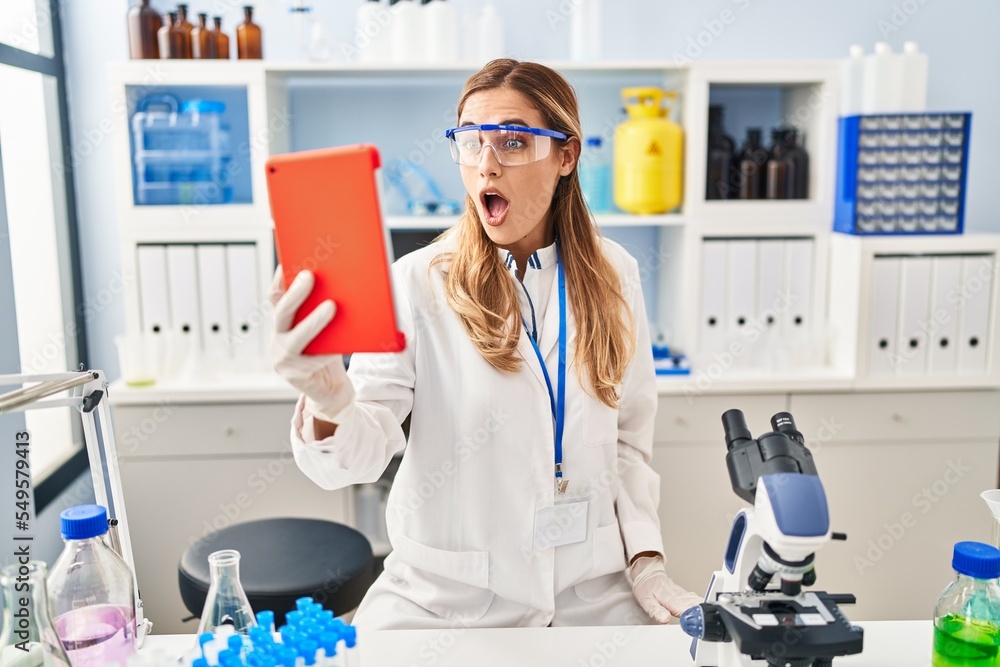 Foto de Young blonde scientist woman on video call working at ...