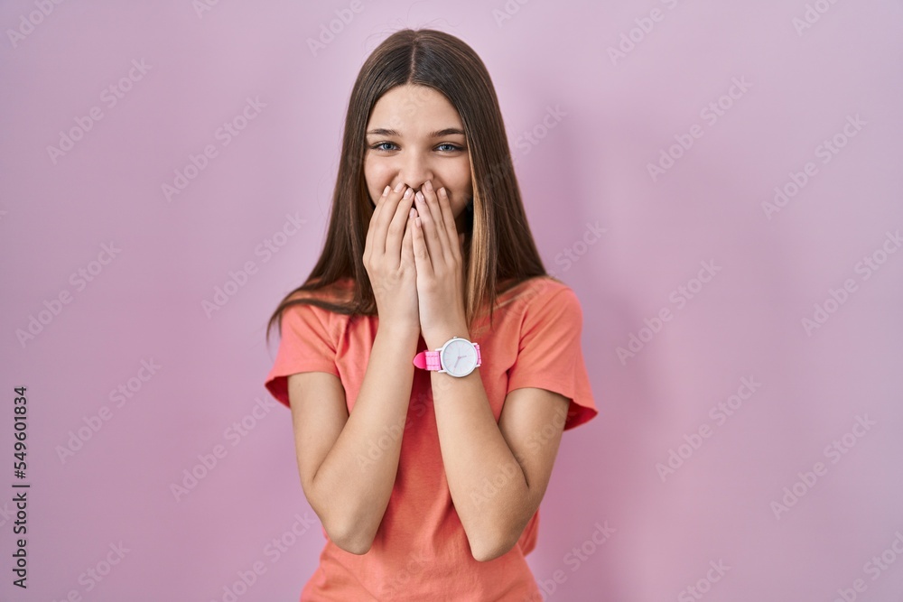Teenager girl standing over pink background laughing and embarrassed ...