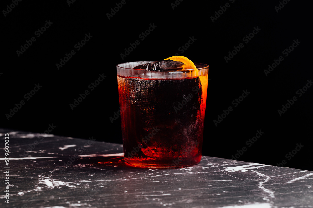 negroni cocktail glass aperitif on a marble table with a black ...