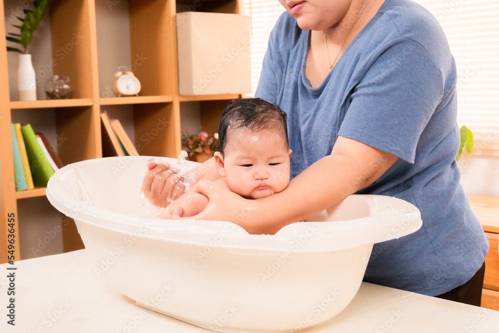 Asian newborn baby in bathtub taking a shower with warm water single ...