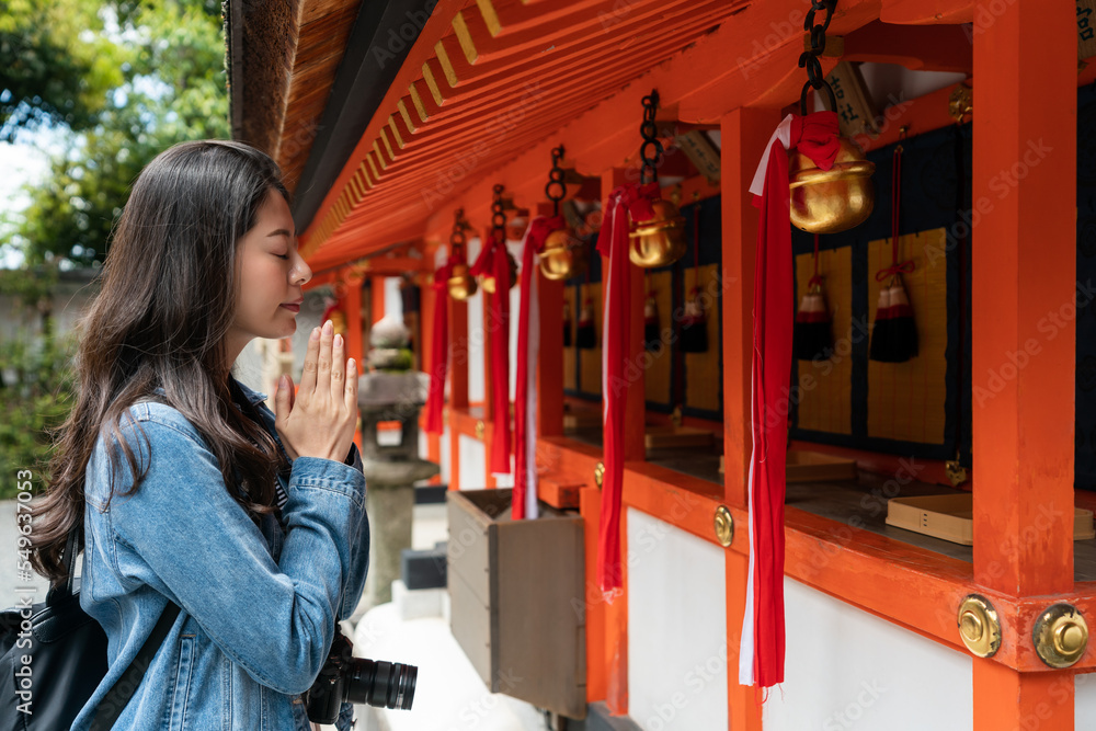 side view portrait of devout asian Japanese girl saying prayers with ...