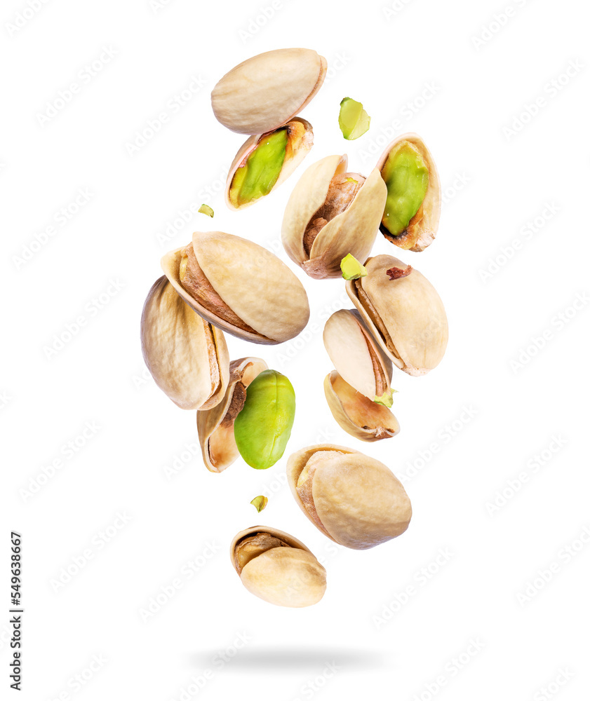 Whole and crushed pistachios close-up in the air on a white background ...