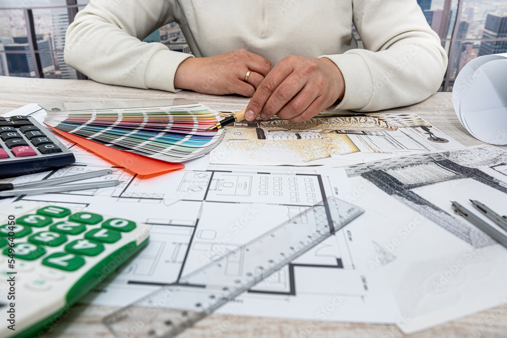 male in the office selects a palette of colors for drawings of the ...