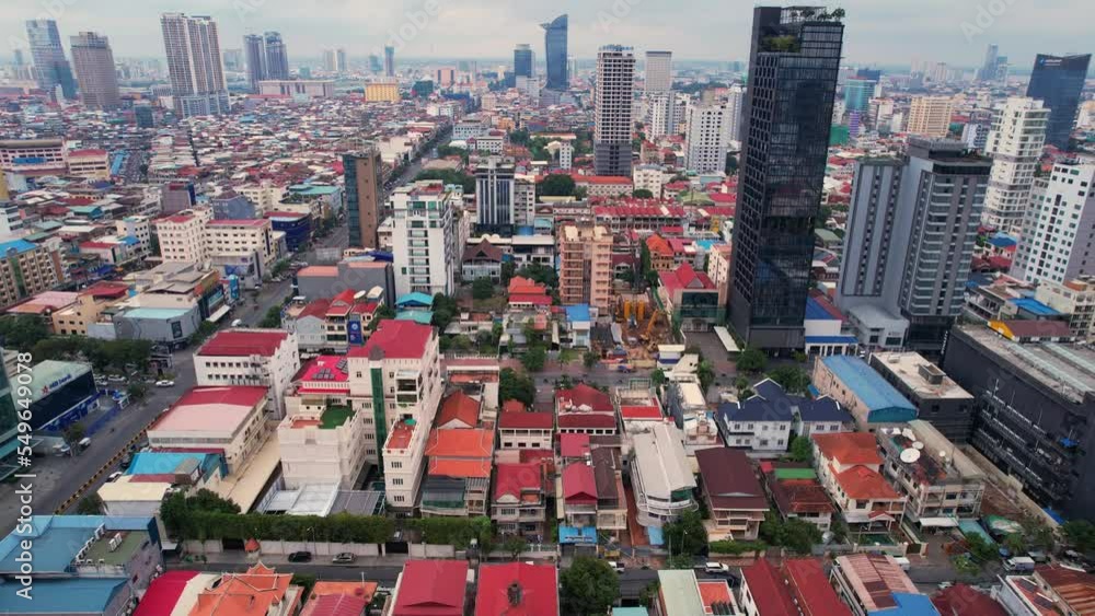 Descending drone footage over Phnom Penh city center between roofs of ...