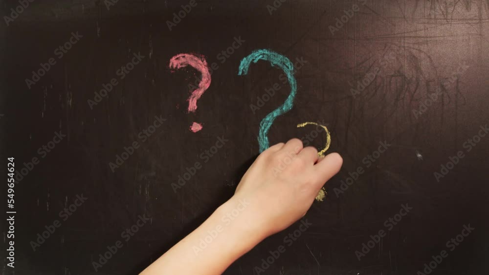 Human hand draws lot of question marks with chalk on blackboard. Many ...