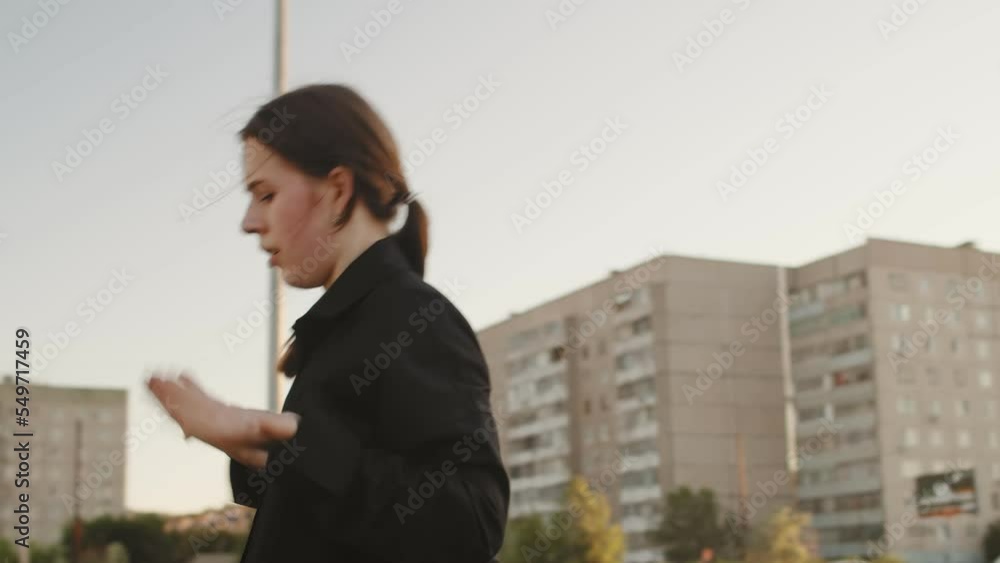 Woman street dancer with long hair deftly folds her hands over chest in ...
