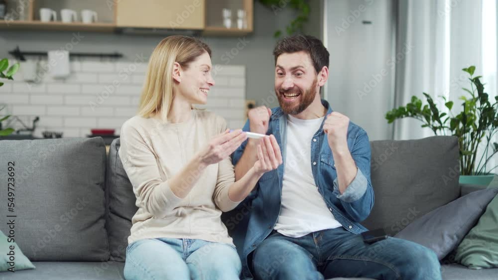 Young smiling woman show to her husband positive pregnancy test and ...