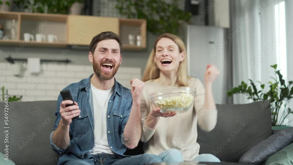 Exited couple sport fans watch football together and celebrating win ...
