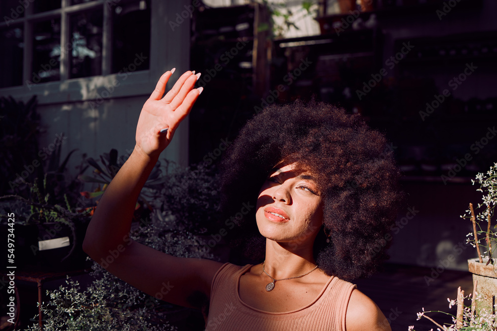 Sun, shadow and hand with a black woman covering her face from the ...