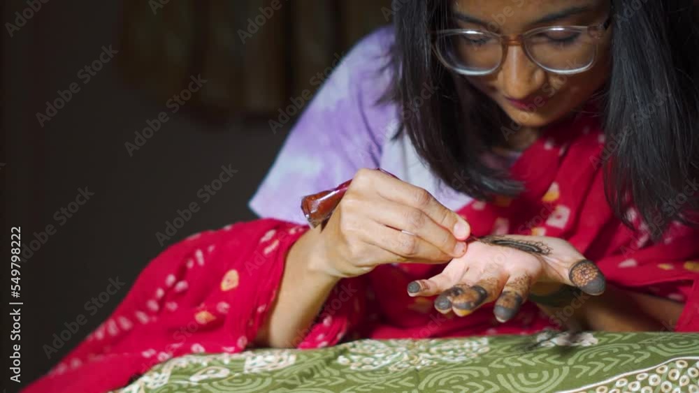 Portrait of Indian girl applying traditional Mehndi on her palm ...
