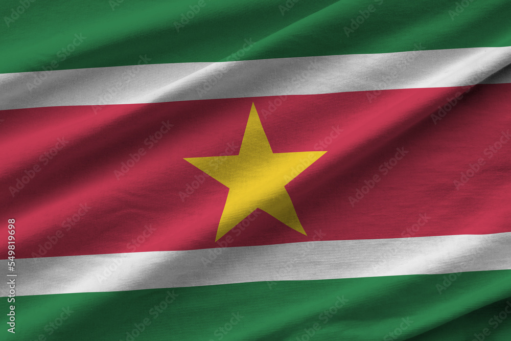 Suriname flag with big folds waving close up under the studio light ...