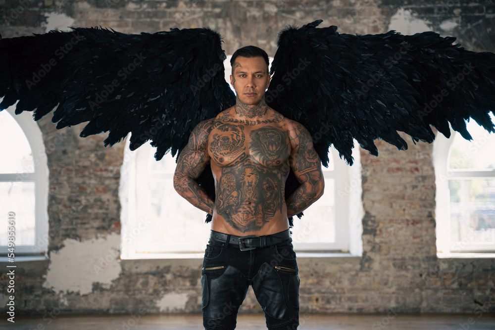 angel man with black wings, stand posing at camera. man fall from ...