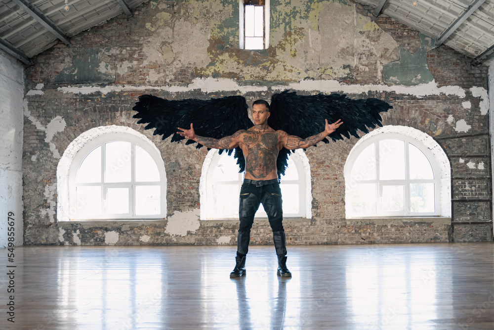 angel man with black wings, stand posing at camera. man fall from ...