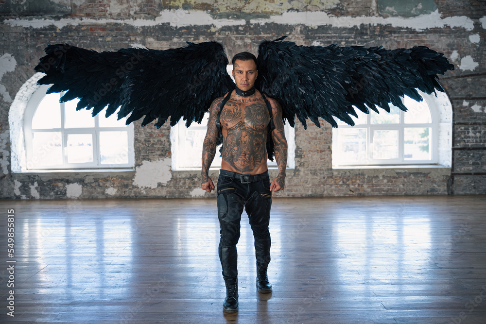 angel man with black wings, stand posing at camera. man fall from ...