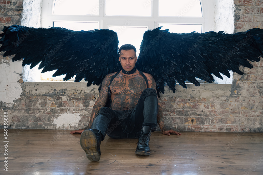 angel man with black wings, stand posing at camera. man fall from ...