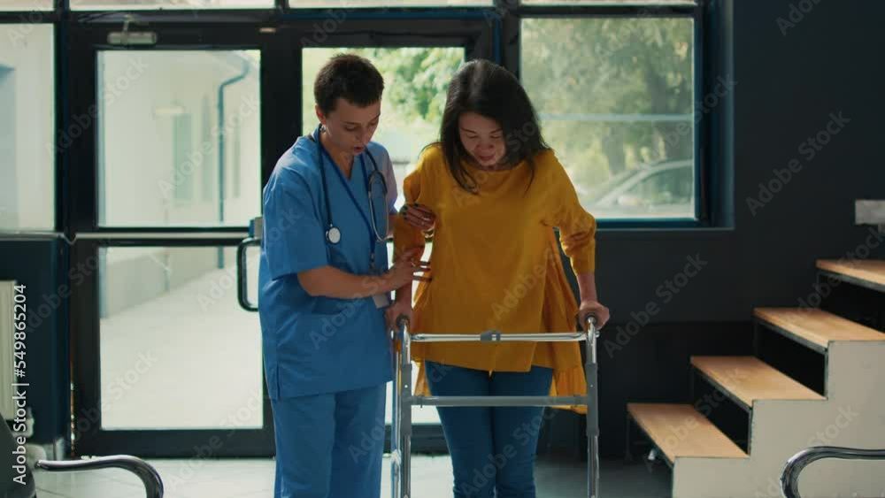 Female nurse helping patient with leg injury to use walk frame, dealing ...