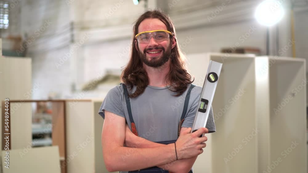 portrait of professional male carpenter holding a sprite level ...