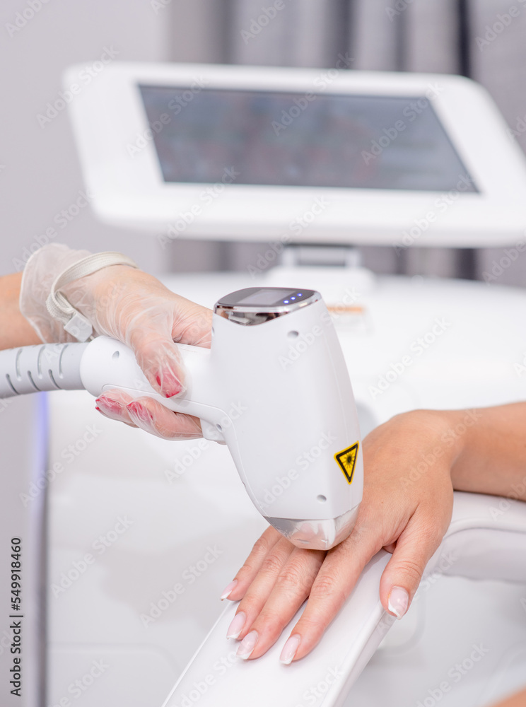 Professional beautician removes hair on beautiful female fingers using ...
