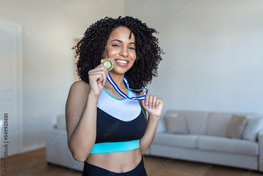 Portrait of an attractive young female athlete posing with her gold ...
