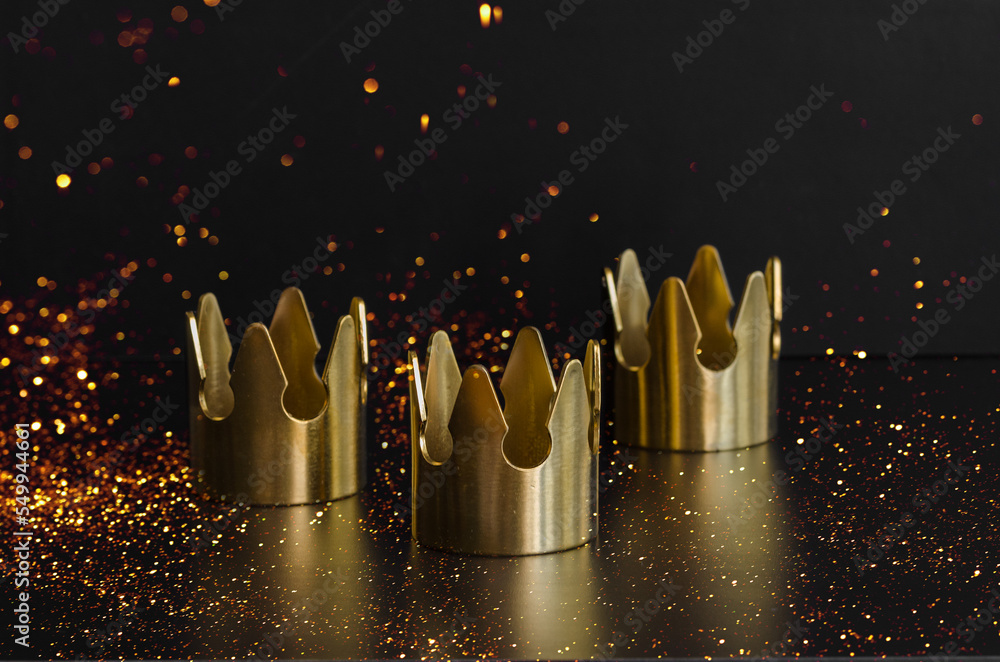 Epiphany Day or Dia de Reyes Magos concept. Three gold crowns on black ...