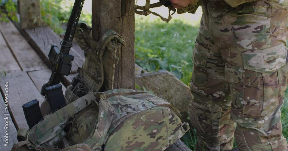Close-up of hands of an unrecognizable male soldier in camouflage ...